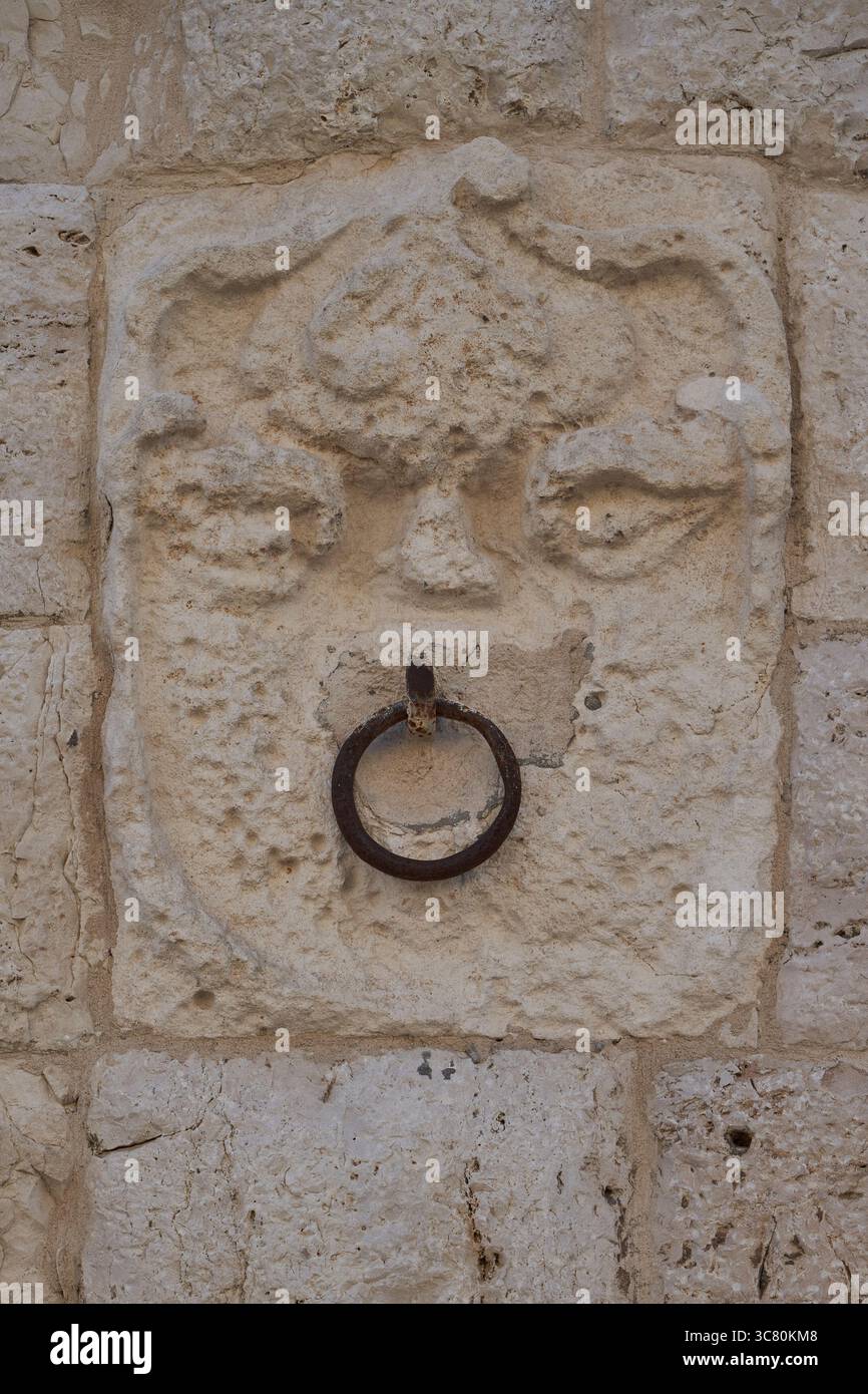 Weathered limestone relief sculpture featuring carved human face with ...