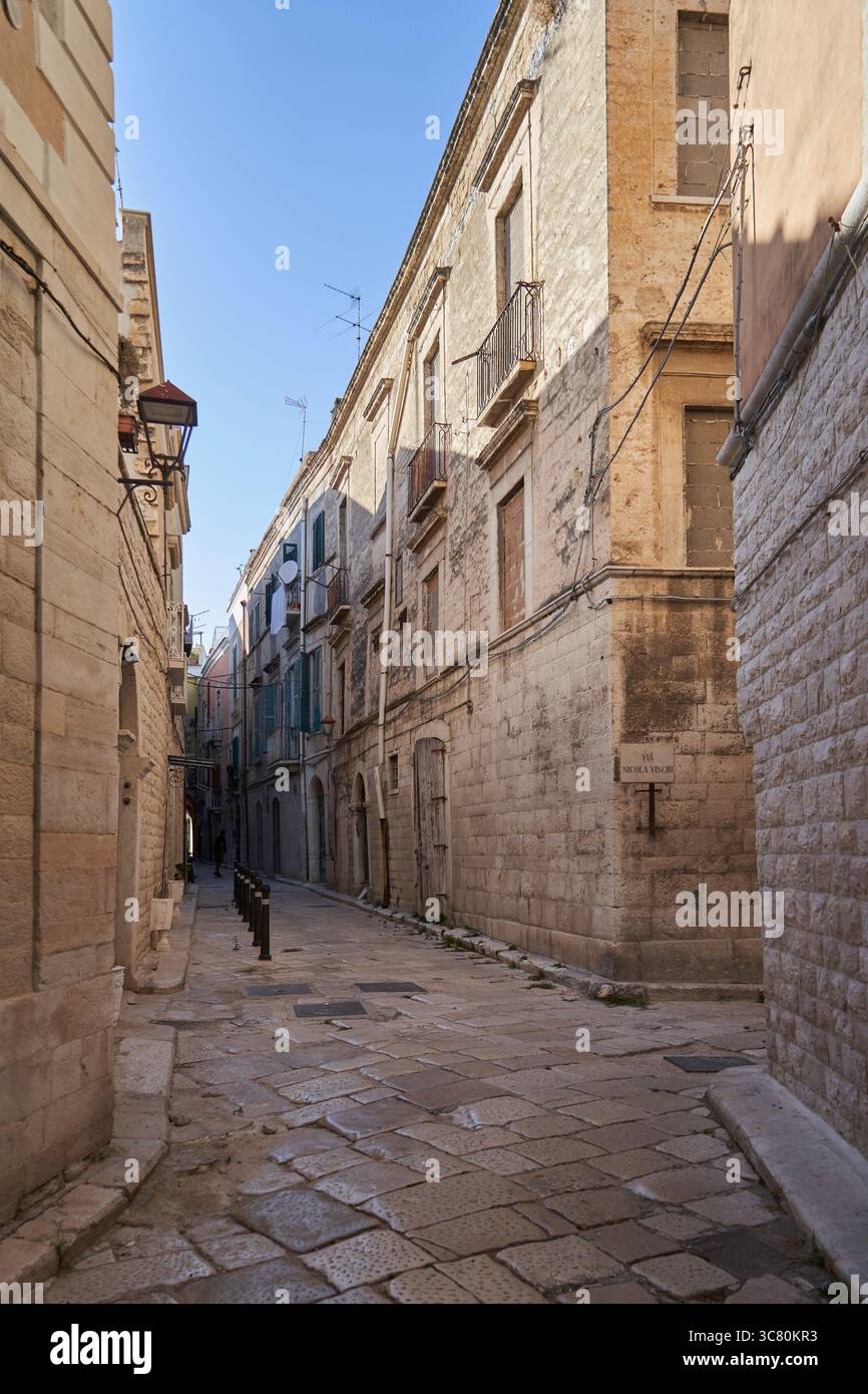 Narrow medieval alley with weathered limestone facades, wrought iron ...