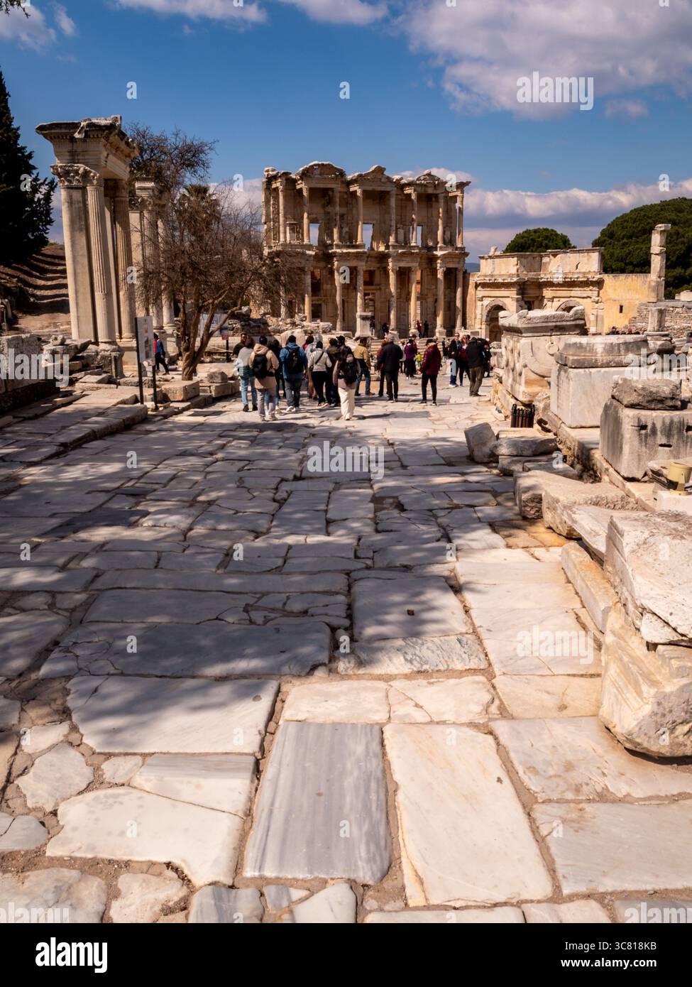 A group of tourists are walking along a stone path towards the Library ...
