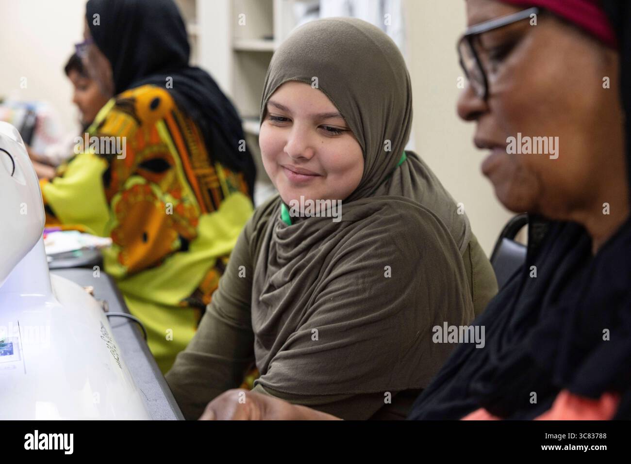 Yusra Jibali, 10, learns how to use a sewing machine with Farzana Khan ...