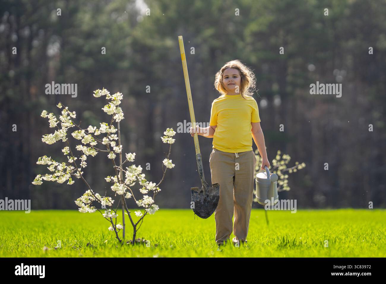 Kid planting a tree in garden. Kid digging soil with shovel and ...