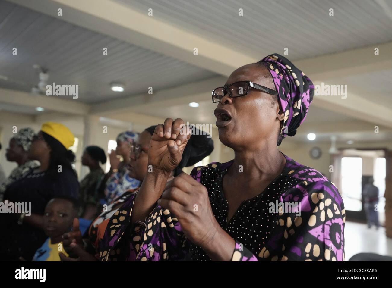A woman uses sign language during a church service at the Christian ...