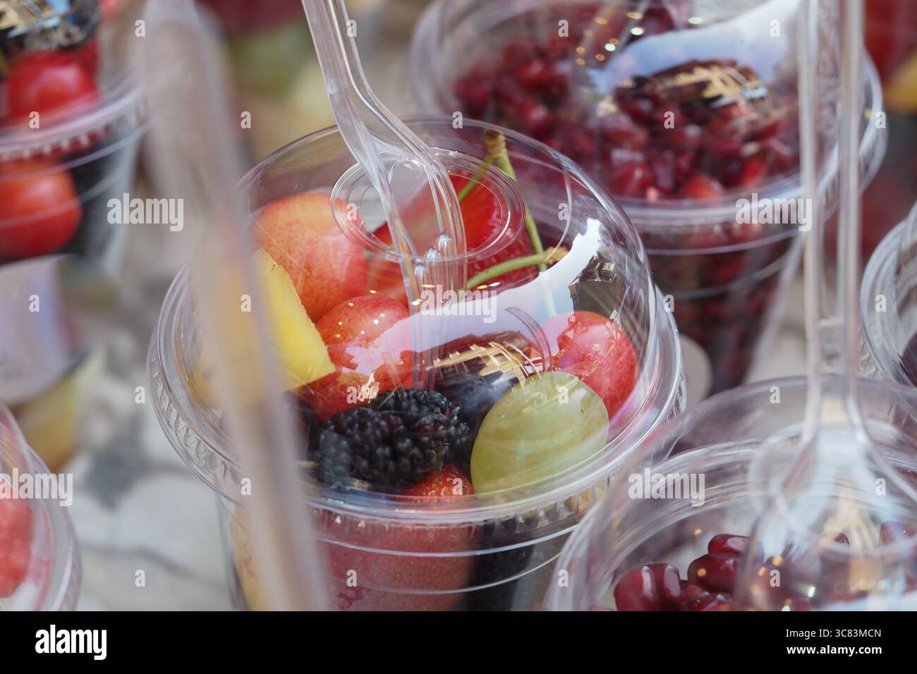 Fresh fruit cups displayed at a market in summer Stock Photo - Alamy