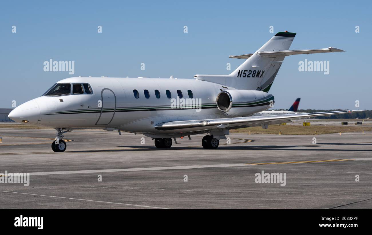 A sleek private jet on an airport runway, ready for takeoff under a ...