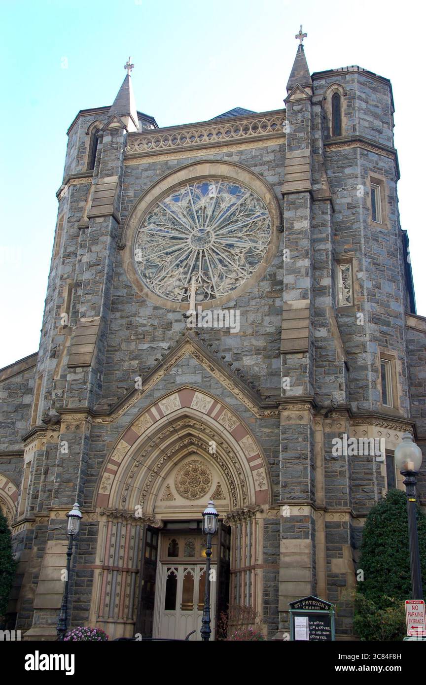 Front view of a historic stone church with a large circular stained ...