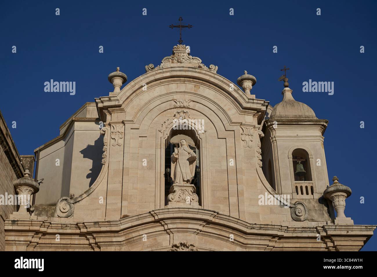 Historic baroque cathedral with detailed carved stonework, saint statue ...