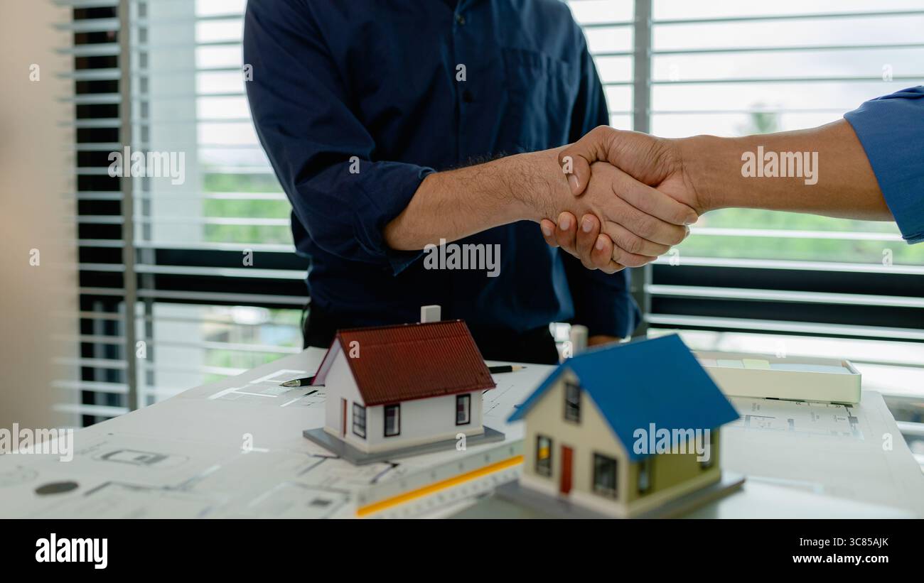 engineer and architect are shaking hands to celebrate because they just ...