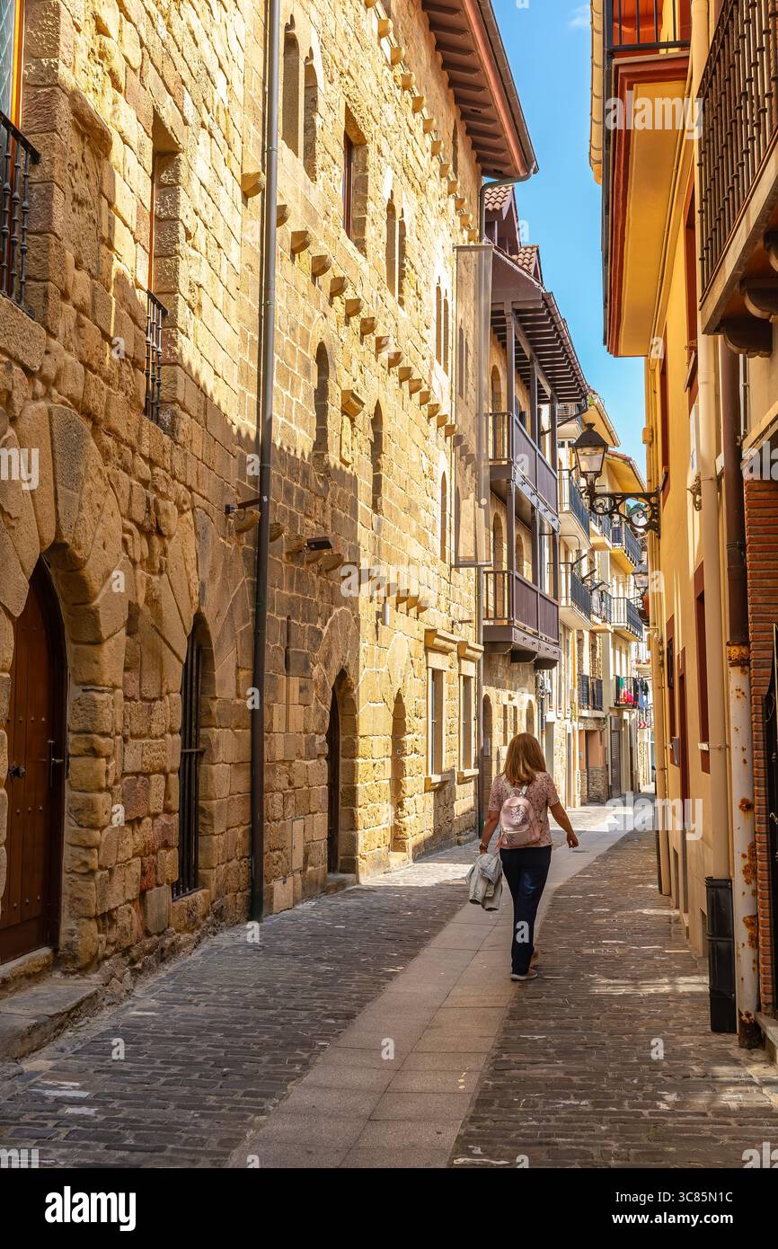 Tourist woman strolling through the pretty narrow streets of the ...