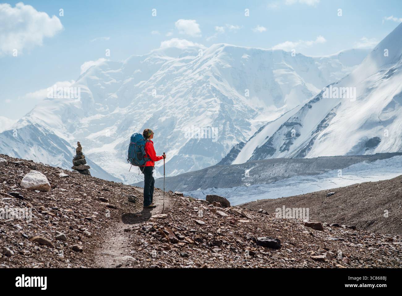 Lonely Climber woman with backpack and trekking poles during Lenin peak ...