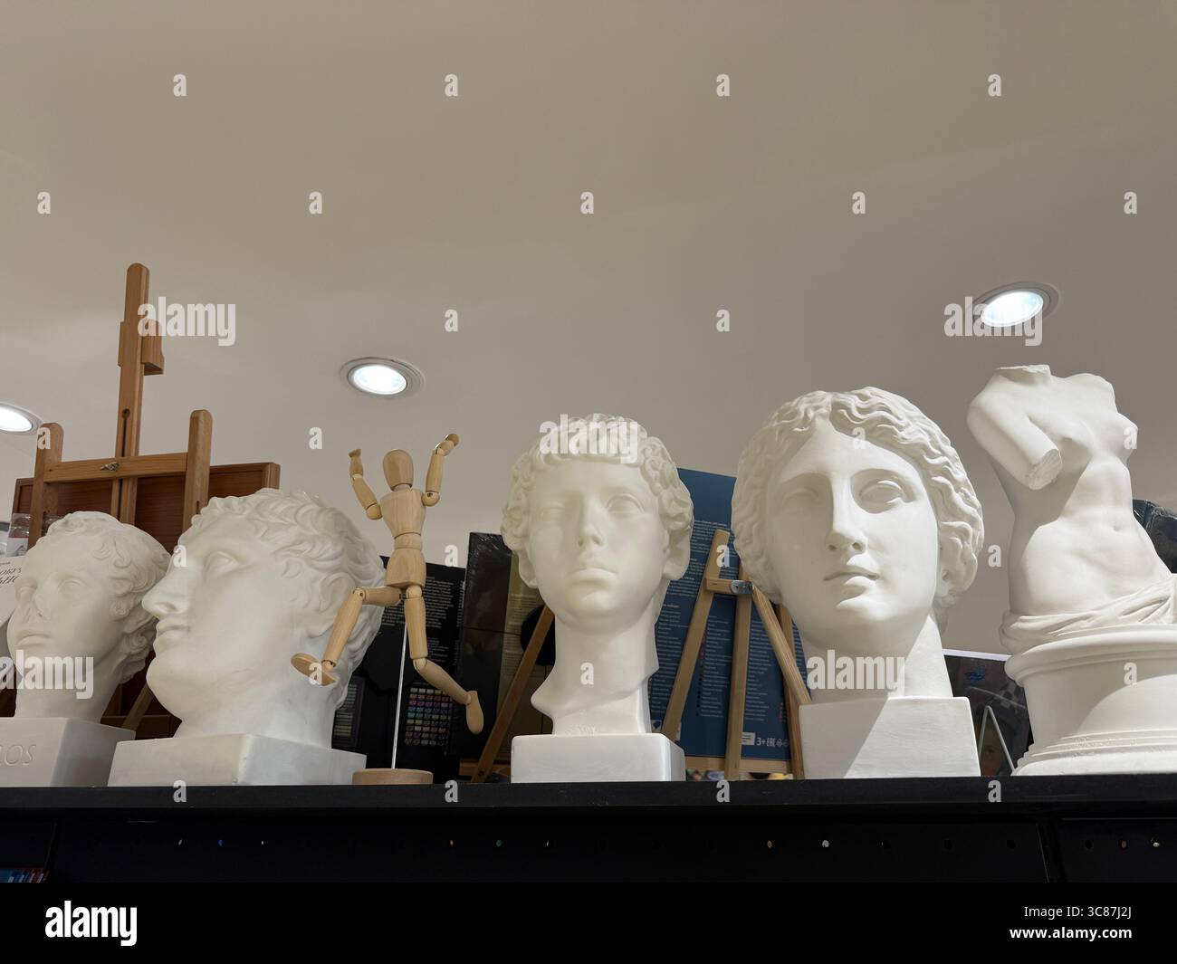 Classical sculpture busts on shelf with wooden mannequin in art display ...