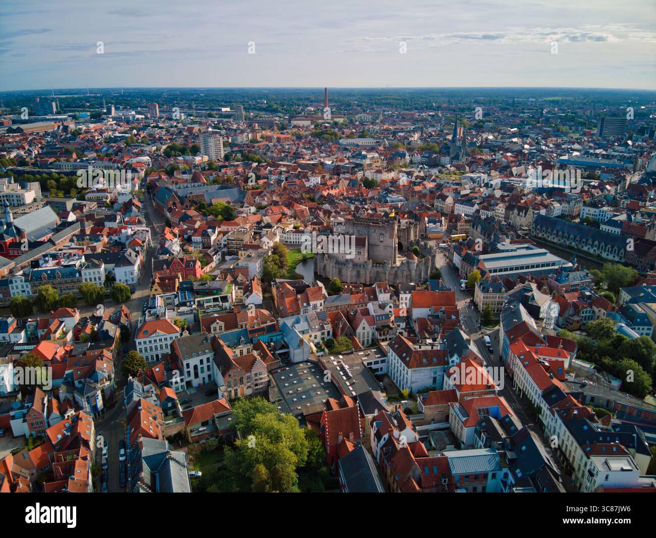 Aerial view of the Gravensteen castle amidst a sea of red-tiled roofs ...