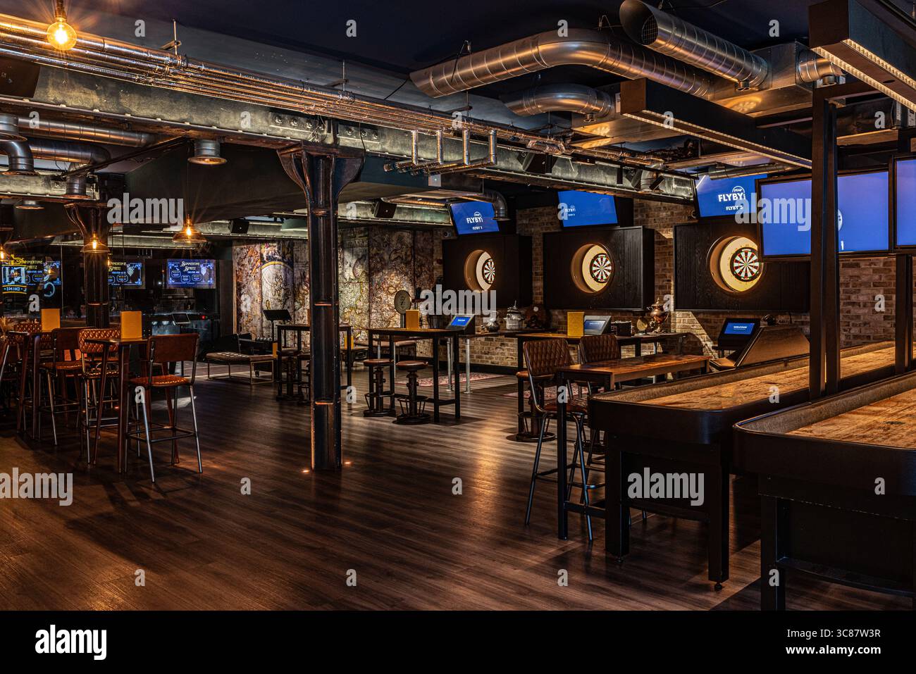 Interior view of an empty dart bar with dartboards and ambient lighting ...