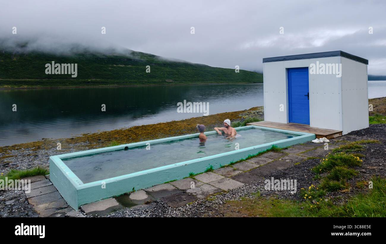 Two individuals enjoy the soothing warmth of a geothermal hot spring ...
