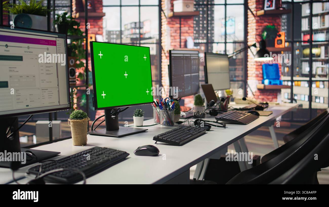 Green screen mockup computer in office next to displays showing data ...