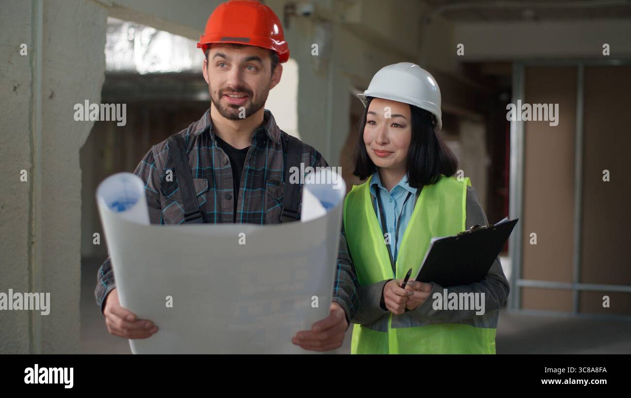 Two diverse Caucasian Japanese builders contractors man woman civil ...