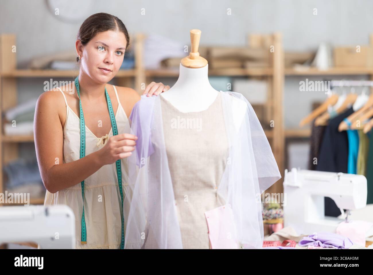 Female dressmaker trying on a dress sample on a mannequin Stock Photo ...