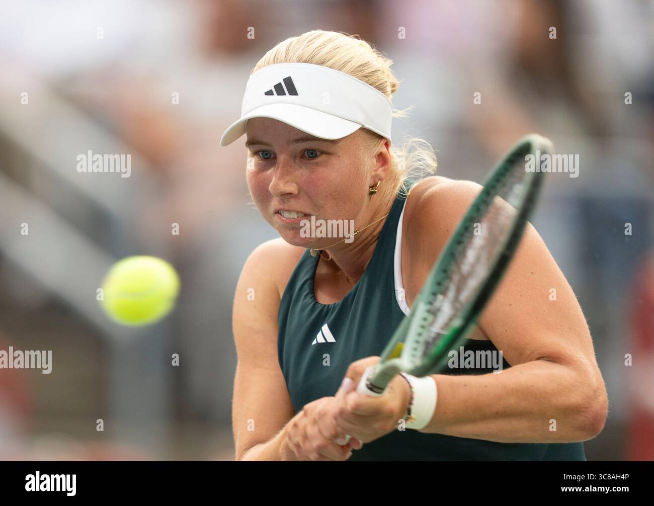 Clara Tauson, of Denmark, hits a return to Iga Swiatek, of Poland ...