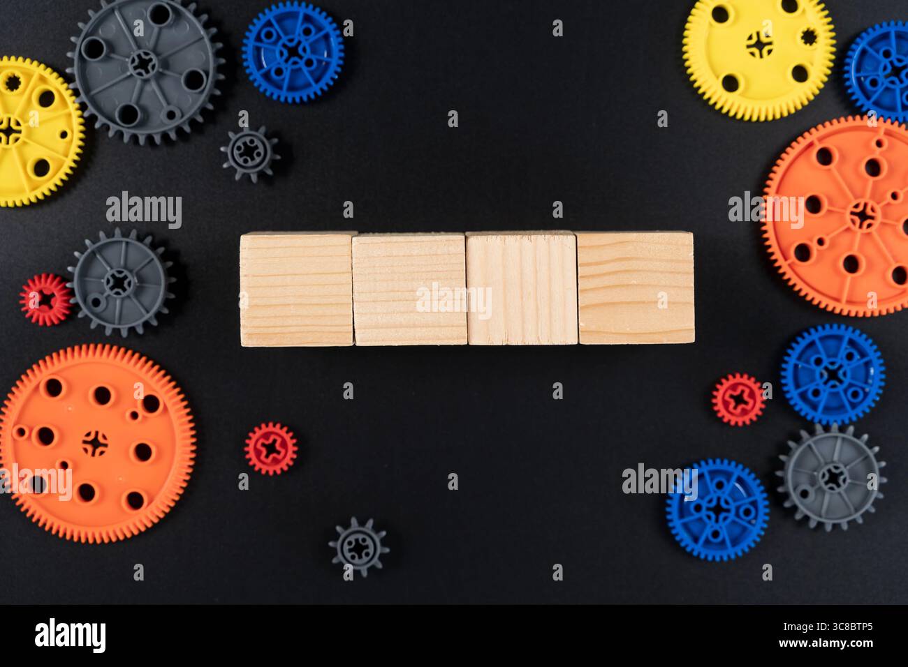 Top view of four natural wooden blocks aligned with colorful plastic ...