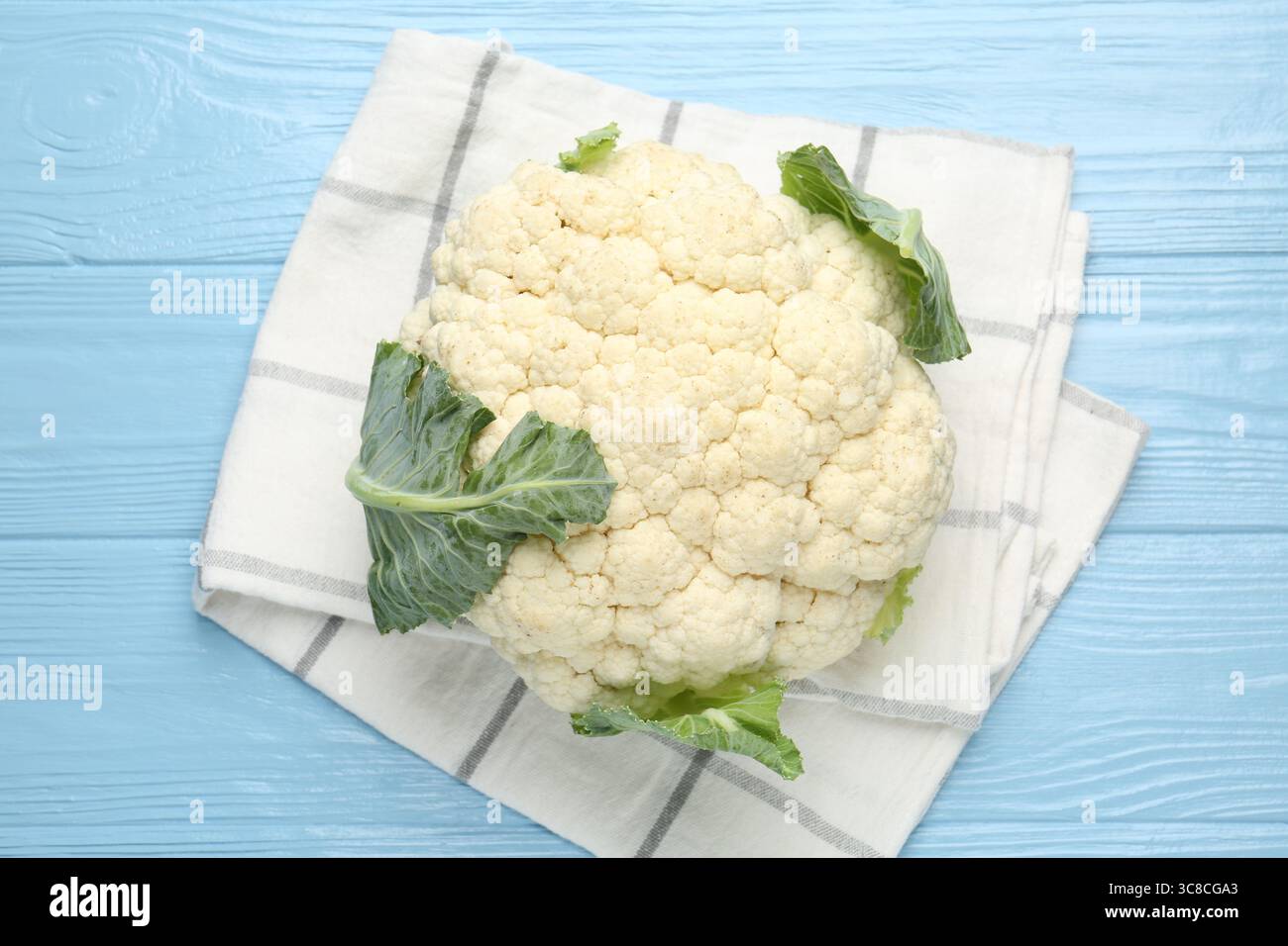 Whole cauliflower on light blue wooden table, top view Stock Photo - Alamy