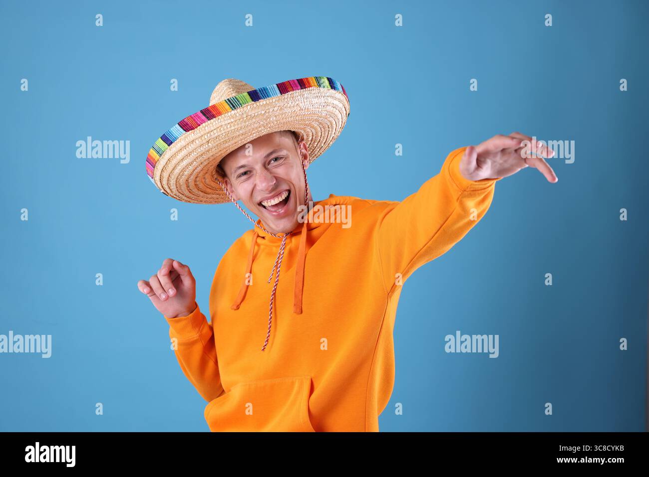 Happy man in sombrero hat dancing on light blue background Stock Photo ...