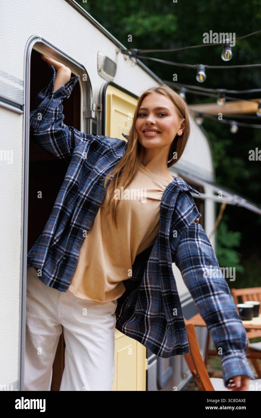 Happy woman in front of her camper van during a trip Stock Photo - Alamy