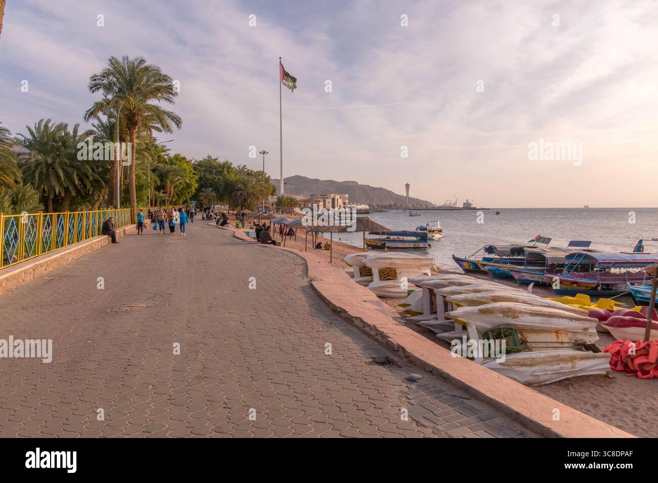 Sunset stroll along Aqaba’s palm-lined beach promenade, locals and ...