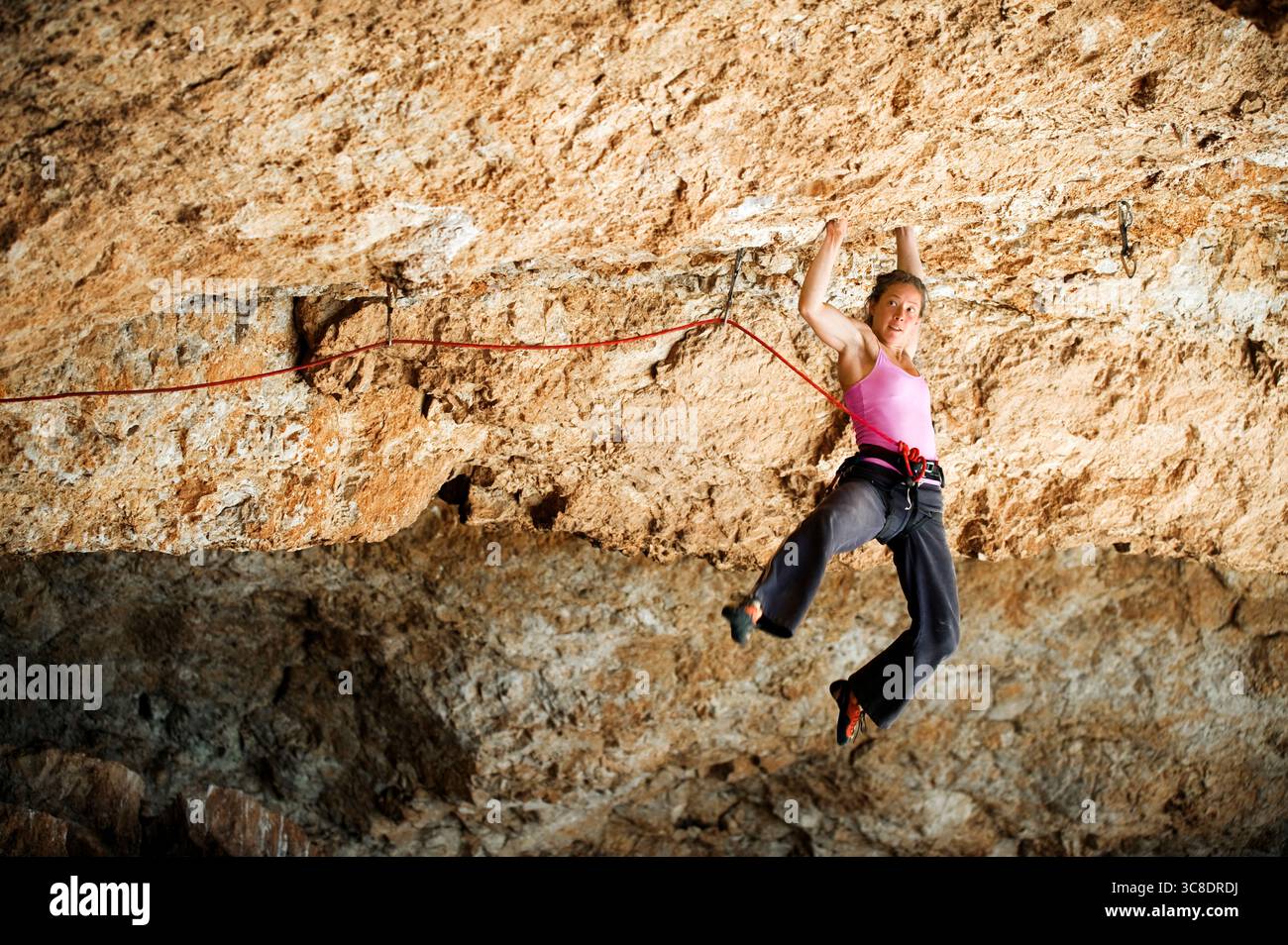 Professional female rock climber climbing a very steep and unique ...