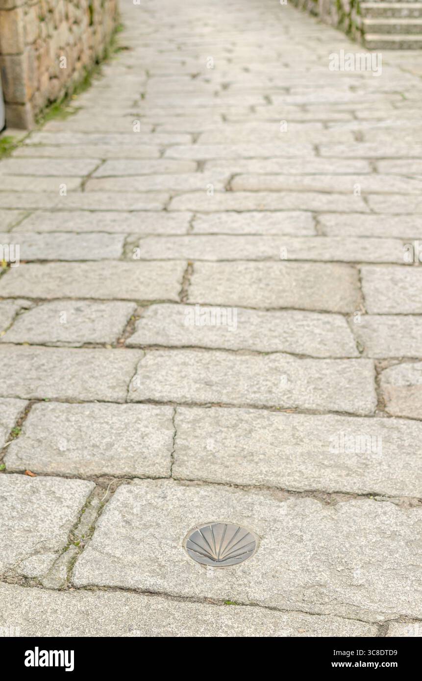 The Way of St. James symbol on an old stone street in Galicia. Follow ...