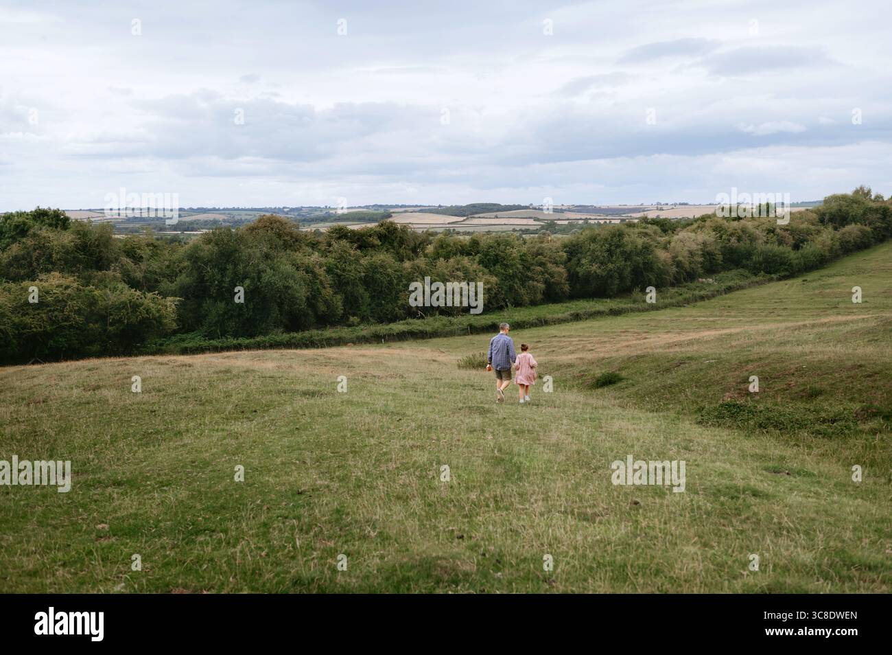 Family walk through the countryside meadow Stock Photo - Alamy