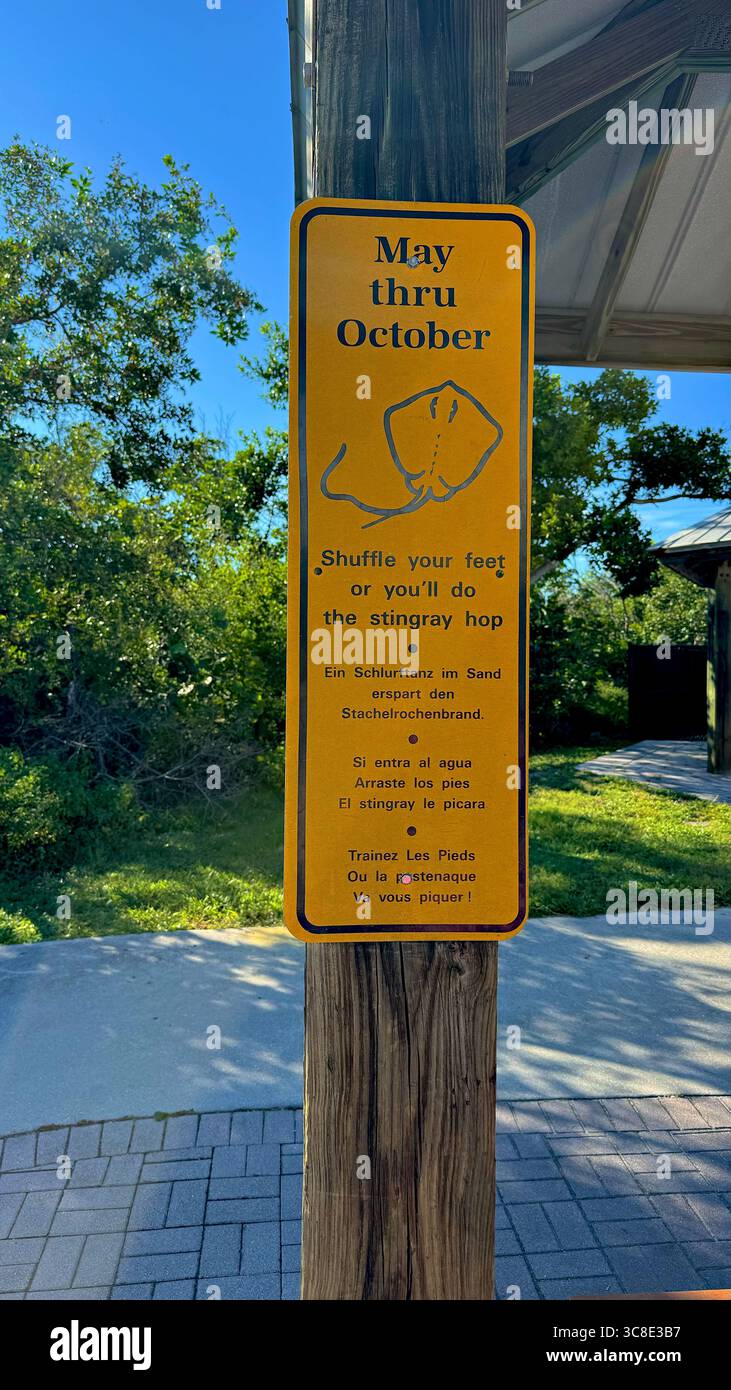 Warning sign in Florida cautioning about stingrays in shallow water and advising to shuffle feet ...