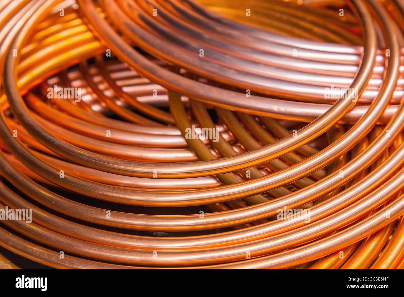 Twisted new copper tubes on a black background Stock Photo - Alamy