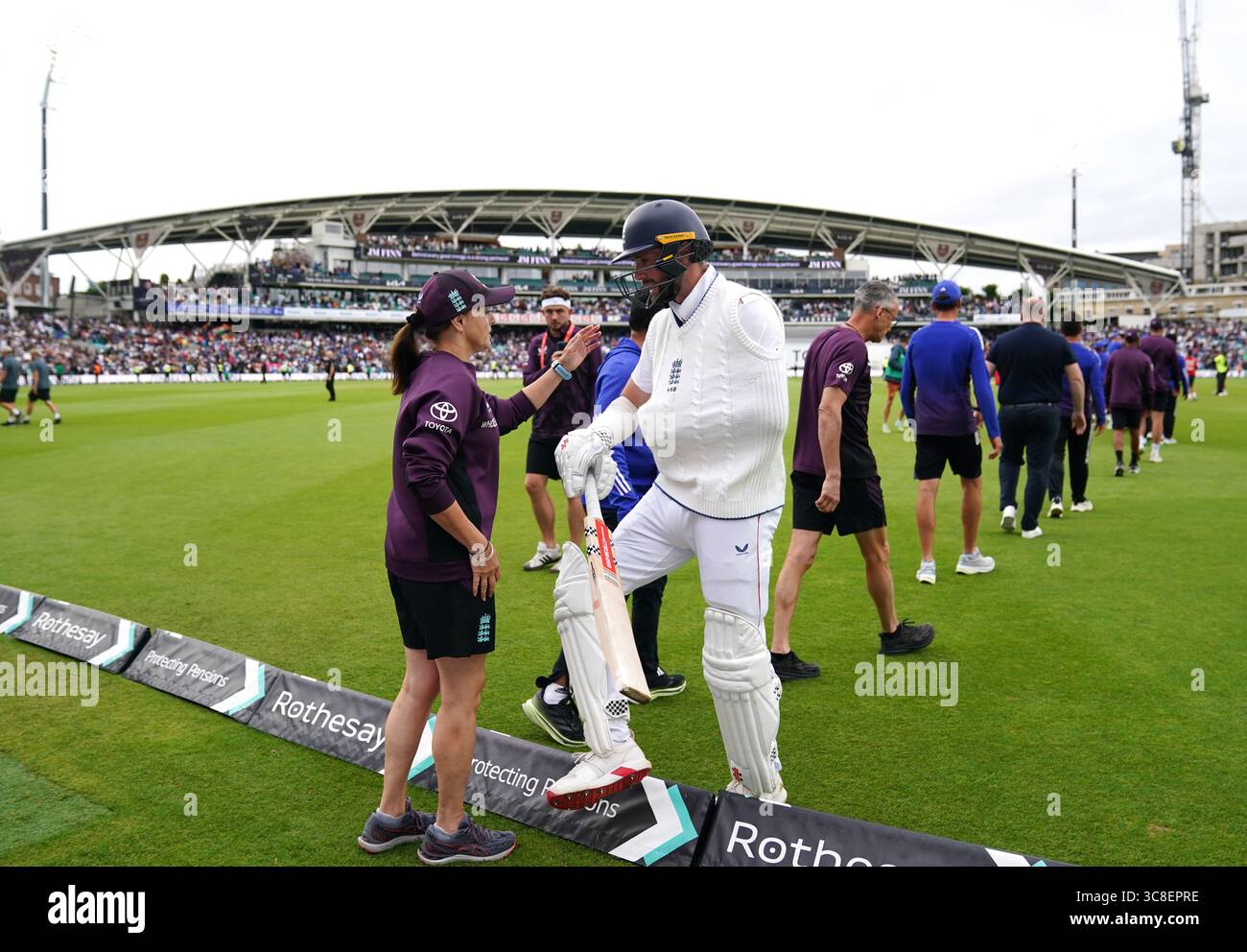 England's Chris Woakes, with his arm in a sling, walks off the field ...