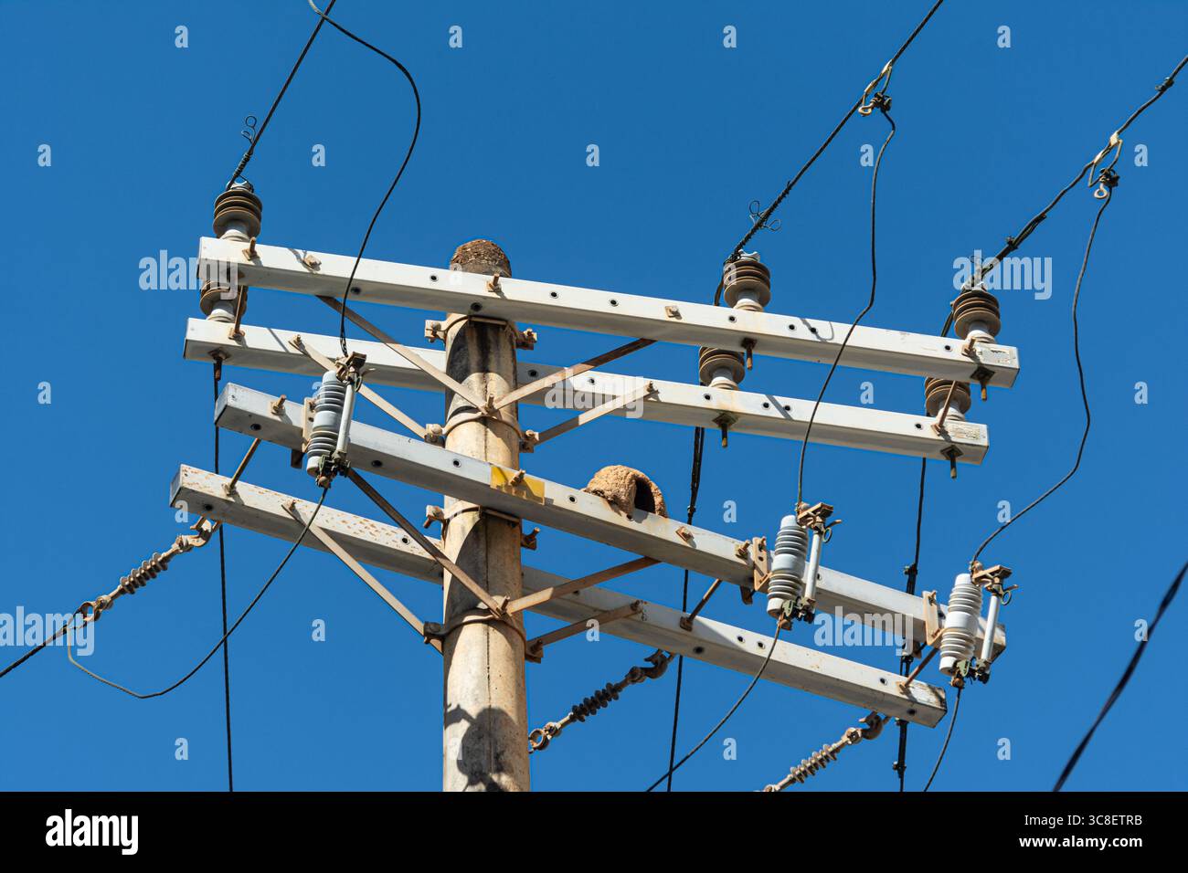 The top of a power pole with a tangle of electrical, internet, and ...