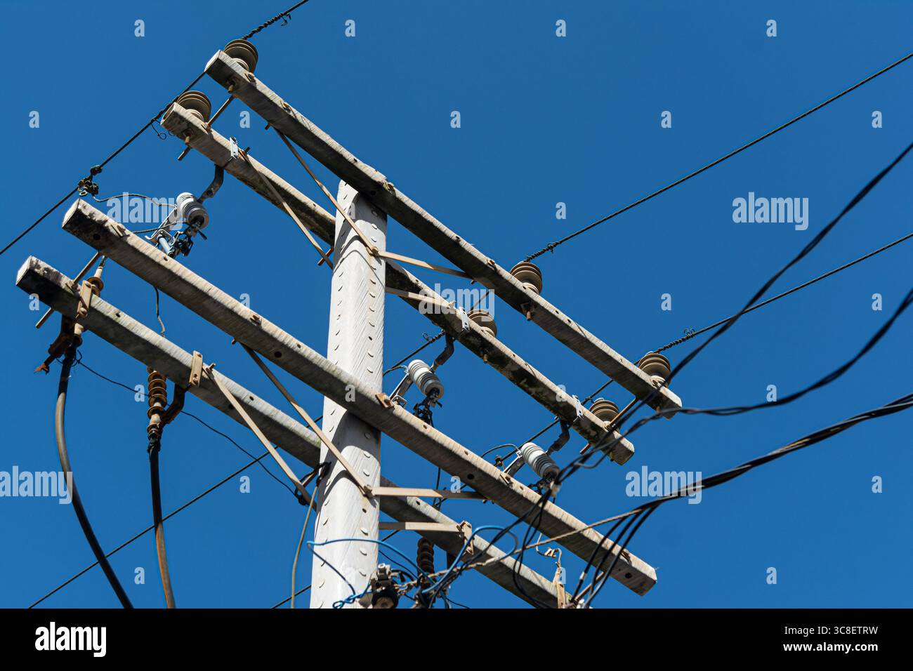 The top of a power pole with a tangle of electrical, internet, and ...