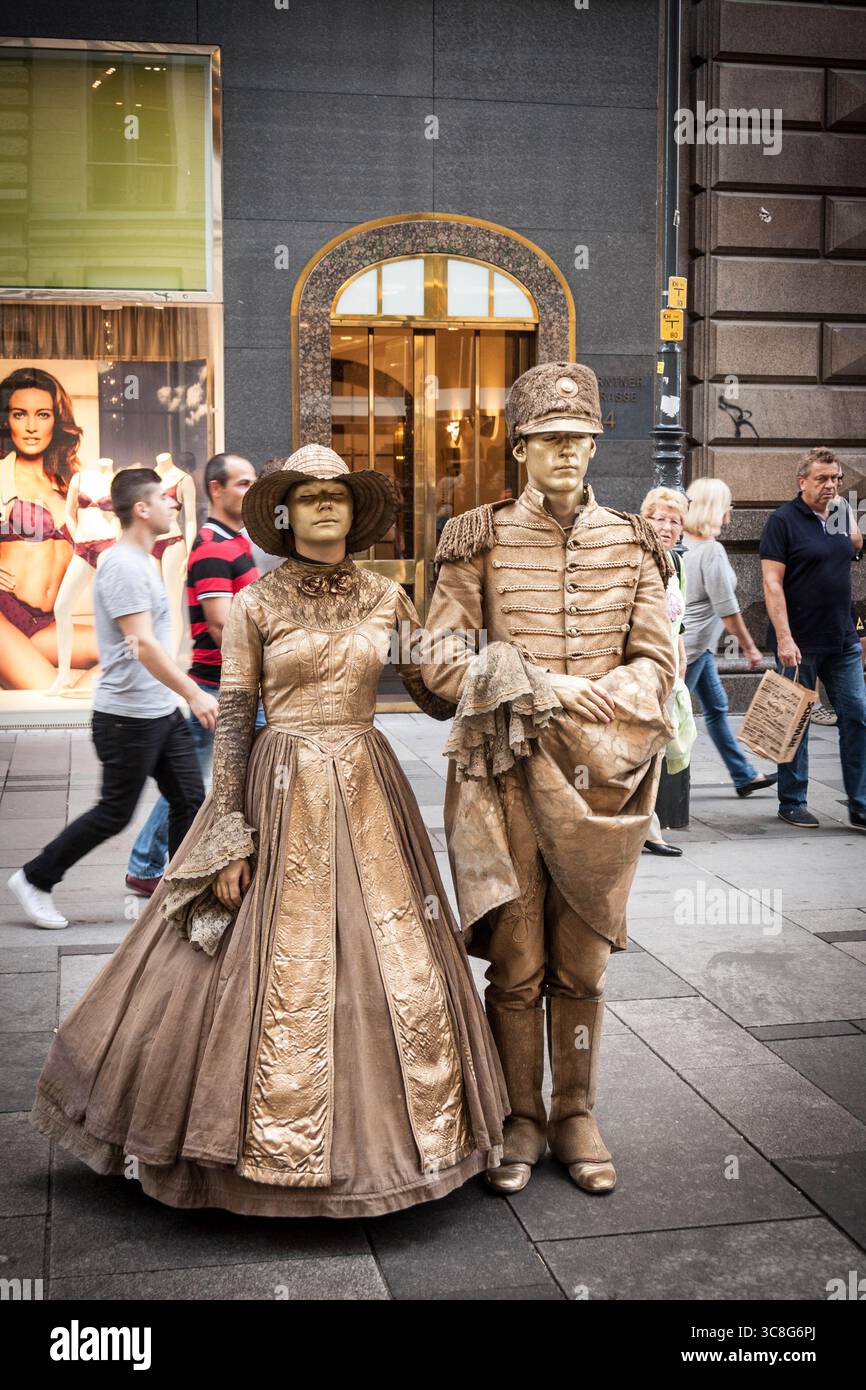 Two street performers in vintage-style costumes pose as living statues ...
