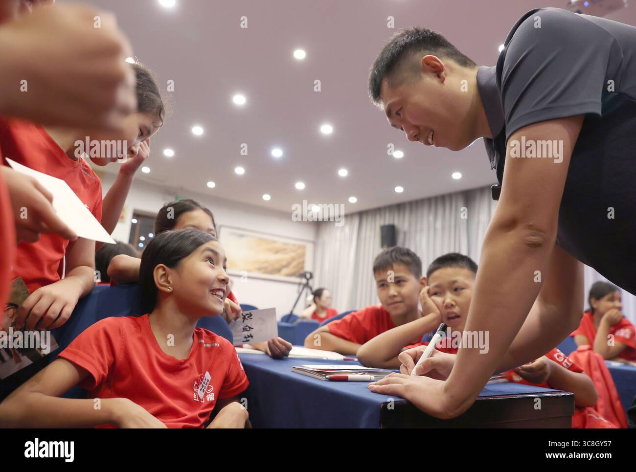 Urumqi, China. 31st July, 2025. Patimanhan Parihat (2nd L) listens as a ...