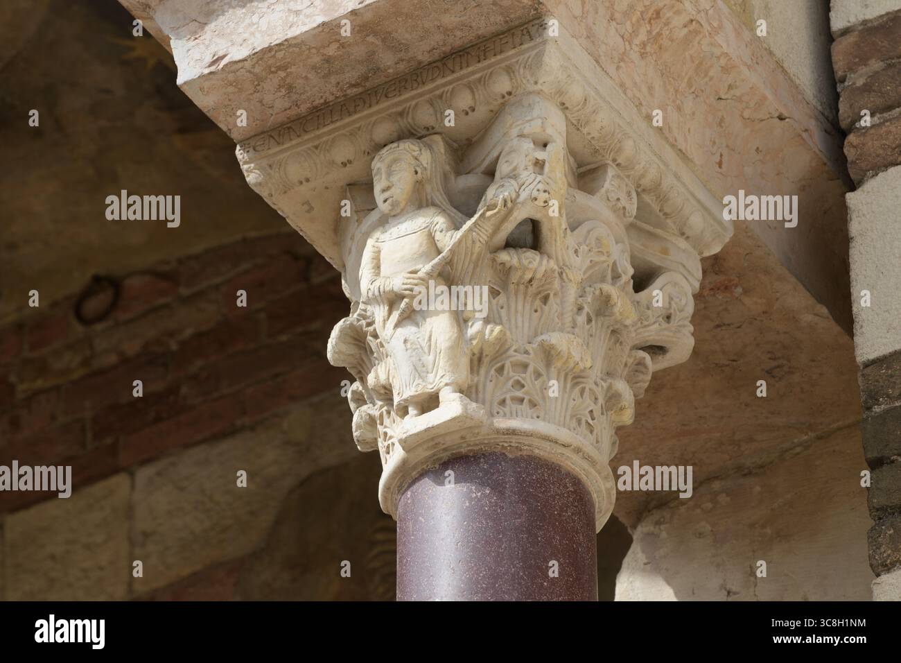 Lateral Romanesque portal with column-bearing lions and faded frescoes ...
