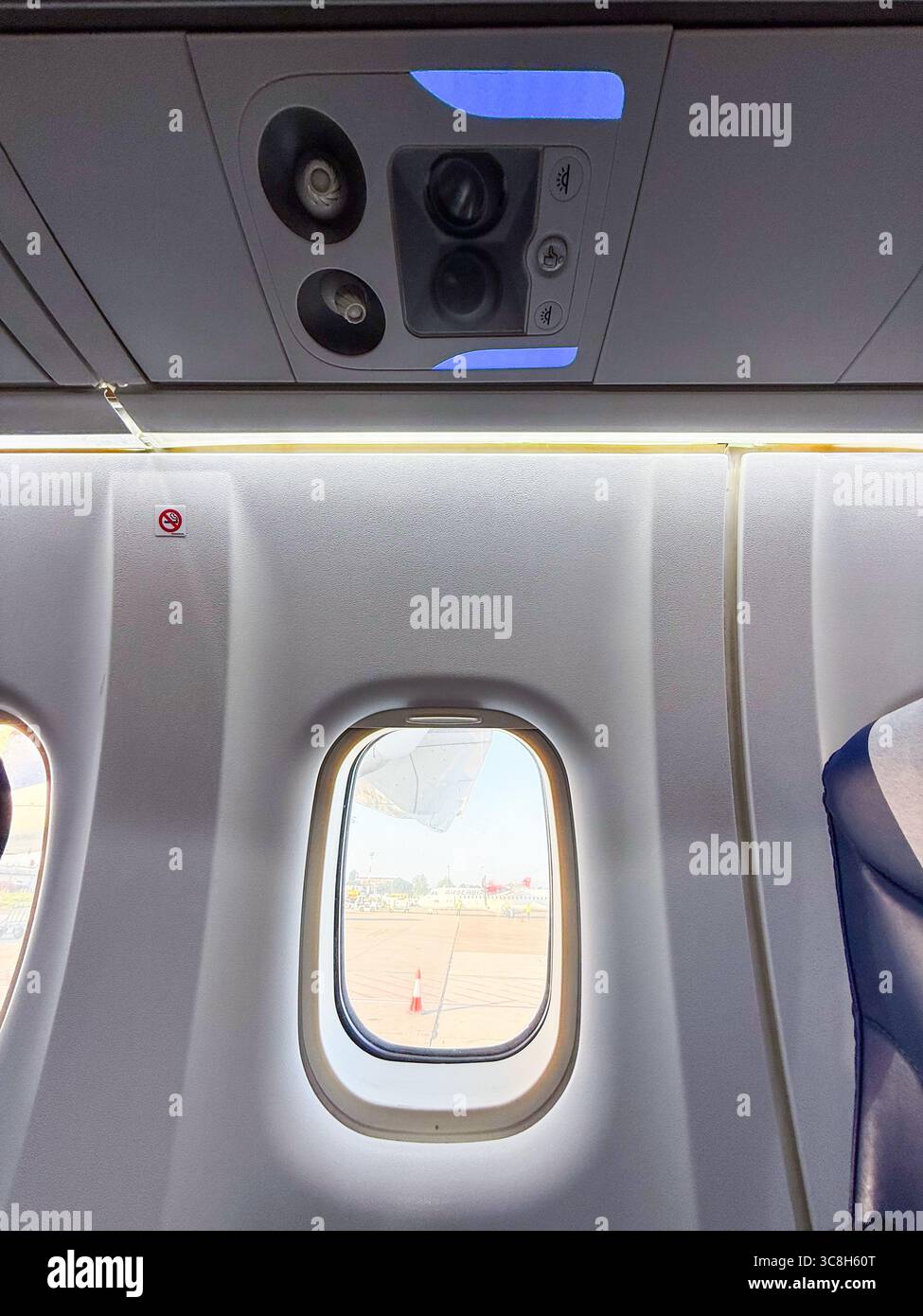 Airplane window view with visible engine and control panel above ...