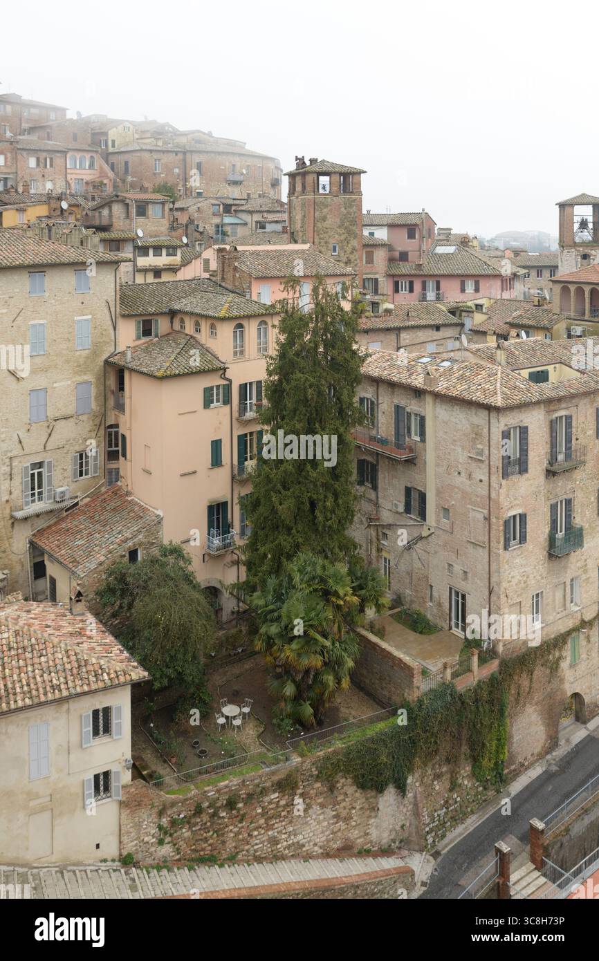 Dense cluster of traditional stone buildings with tiled roofs in foggy ...