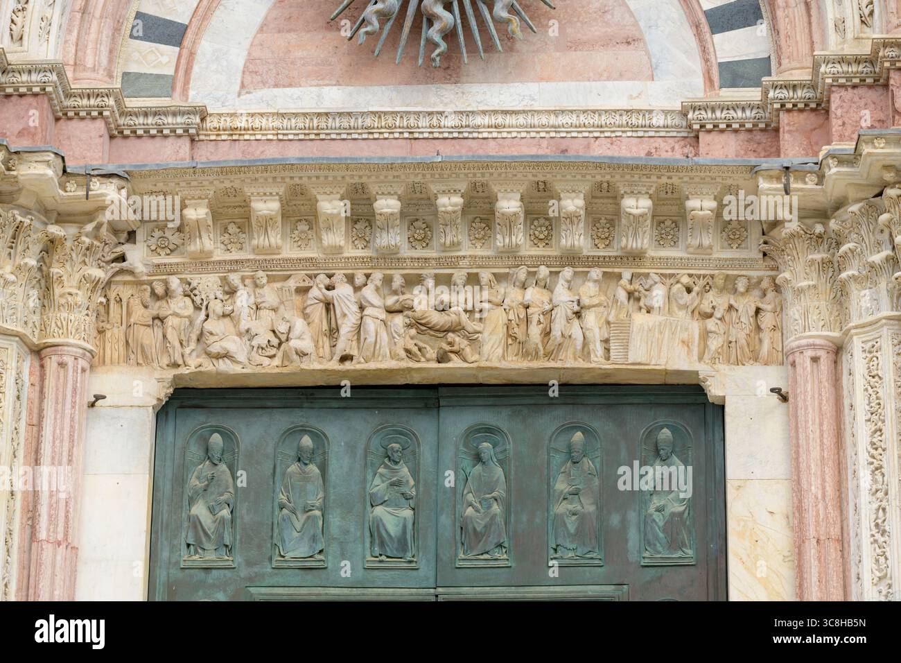 Detail of pointed gable, statues, and arches on the main portal of ...