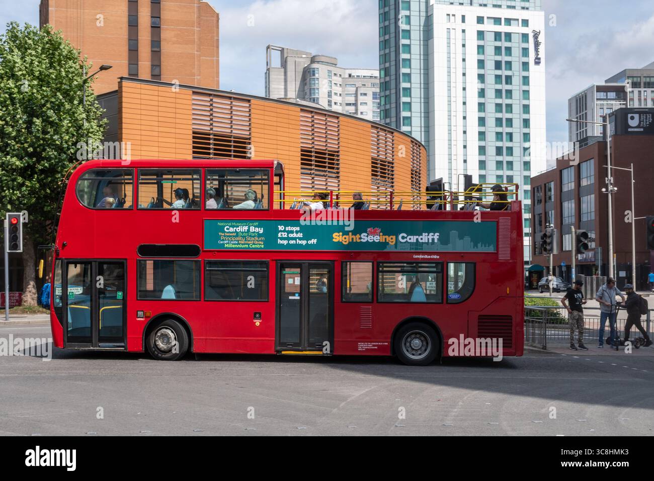 Tourists riding on a Cardiff Sightseeing bus, half open-topped hop on ...