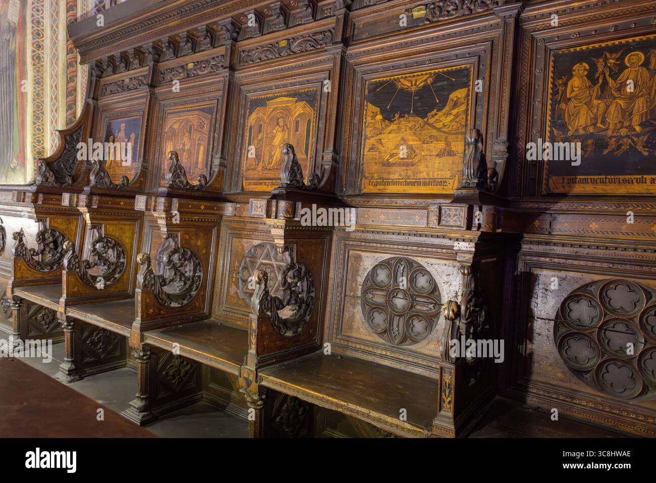 Wooden choir stalls with intricate marquetry panels depicting religious ...
