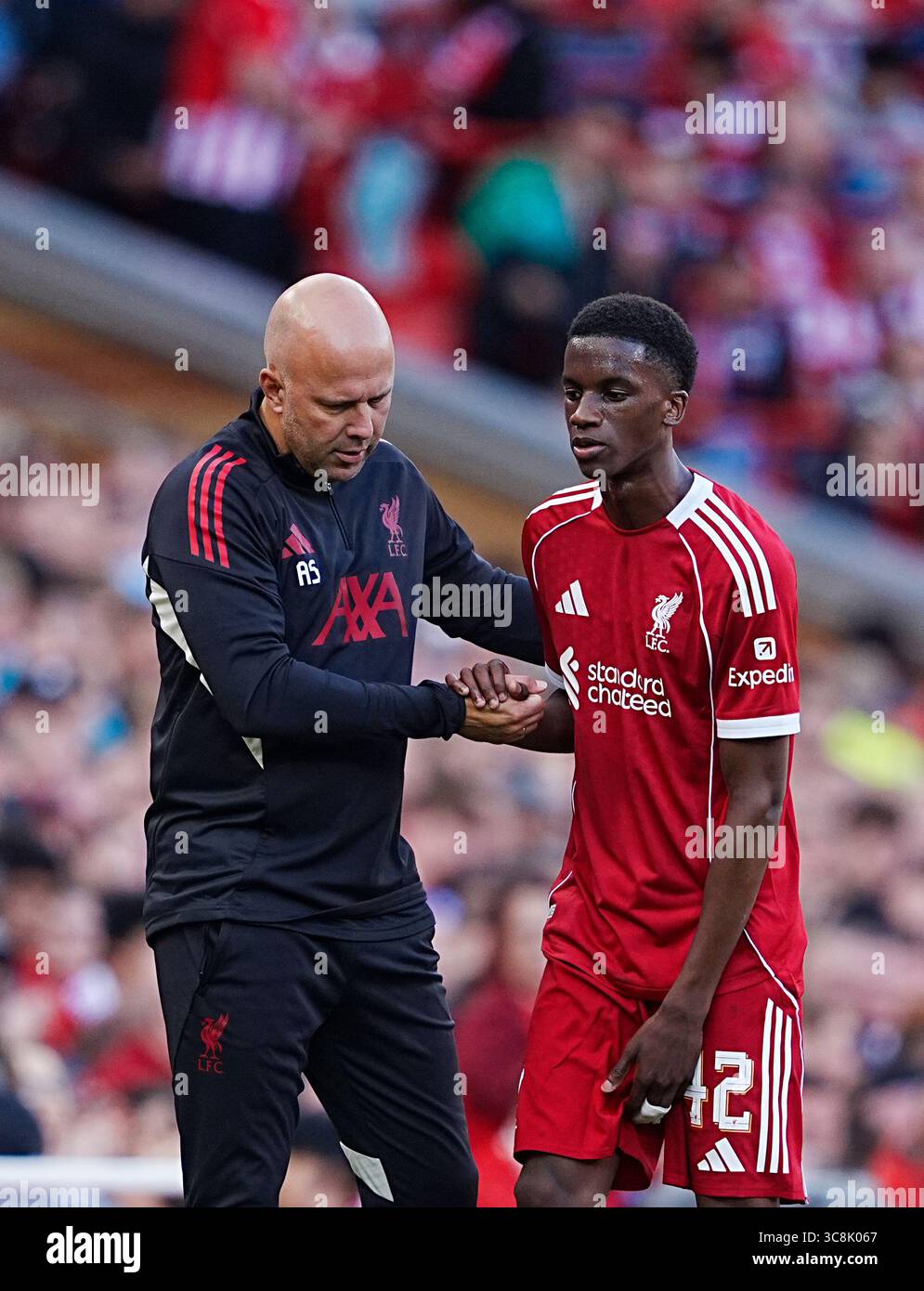 Liverpool manager Arne Slot shakes the hand of Trey Nyoni as he comes ...