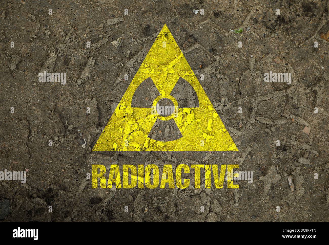 Yellow radioactive sign on ground with tire tracks, closeup ...