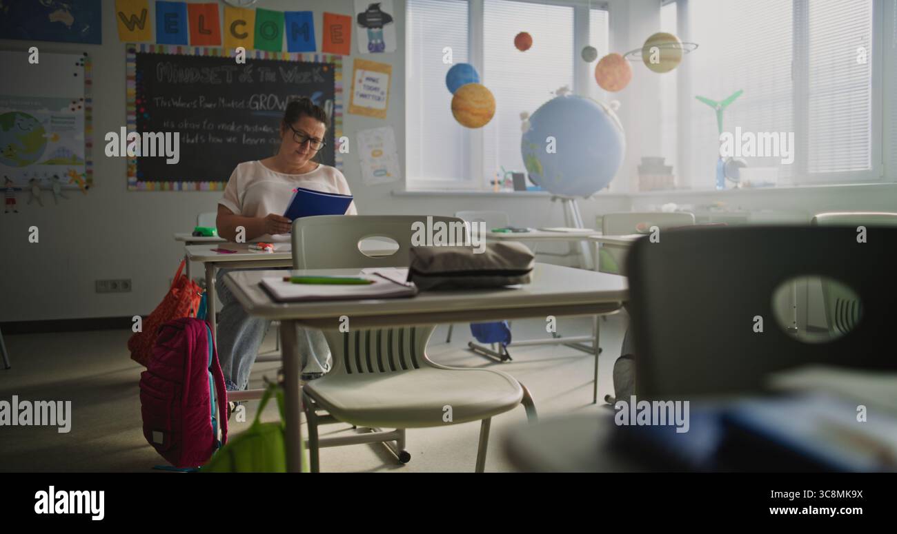 Exhausted Female Teacher Sitting Alone at Desk in Empty Classroom ...