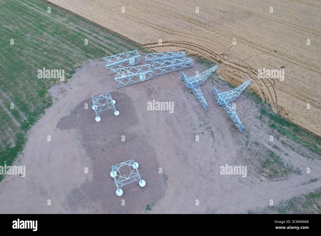High-voltage pylon disassembled on ground with concrete bases before ...