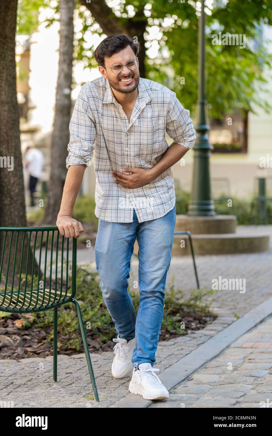 Arabian young man traveler feeling sudden strong abdominal stomach ache ...