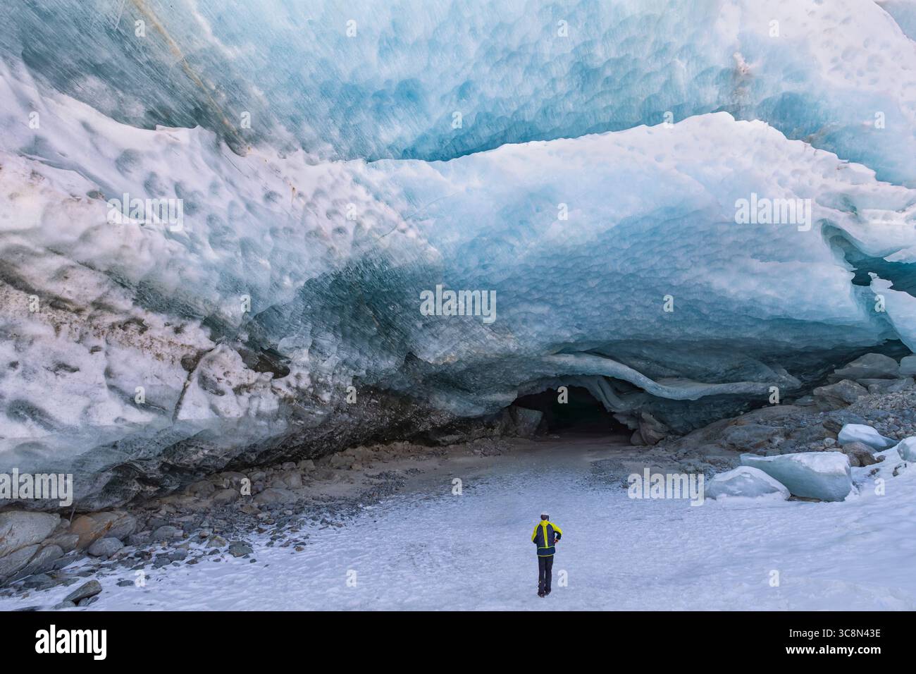 An ice cave entrancet with huge collapsed cracks hanging overheand ...
