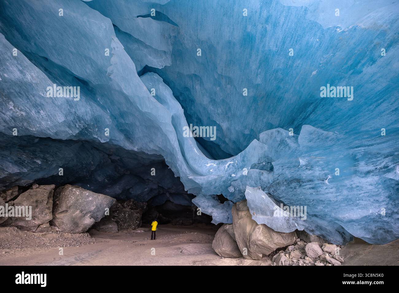 Dangerous ice cave entrance with huge hanging ice block overhead in the ...