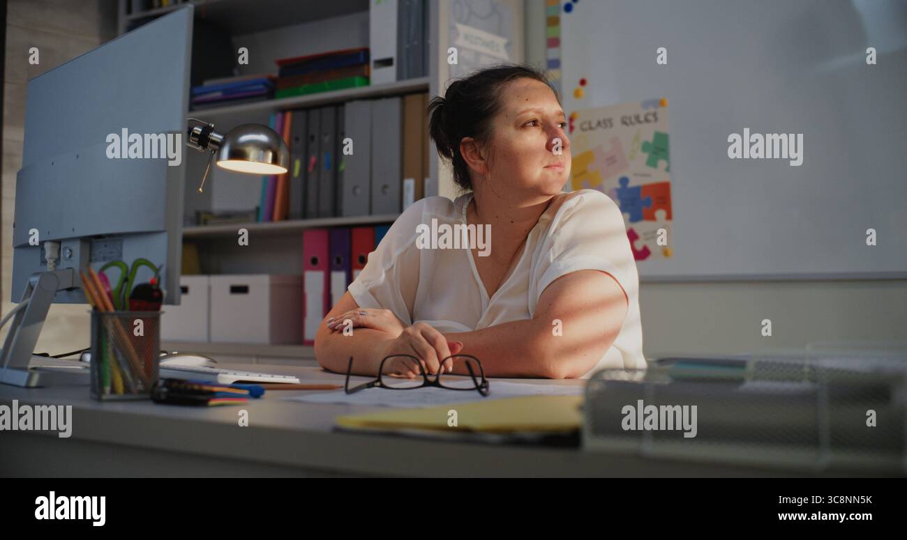Exhausted Female Teacher Sitting at Computer in Empty Classroom, Having ...